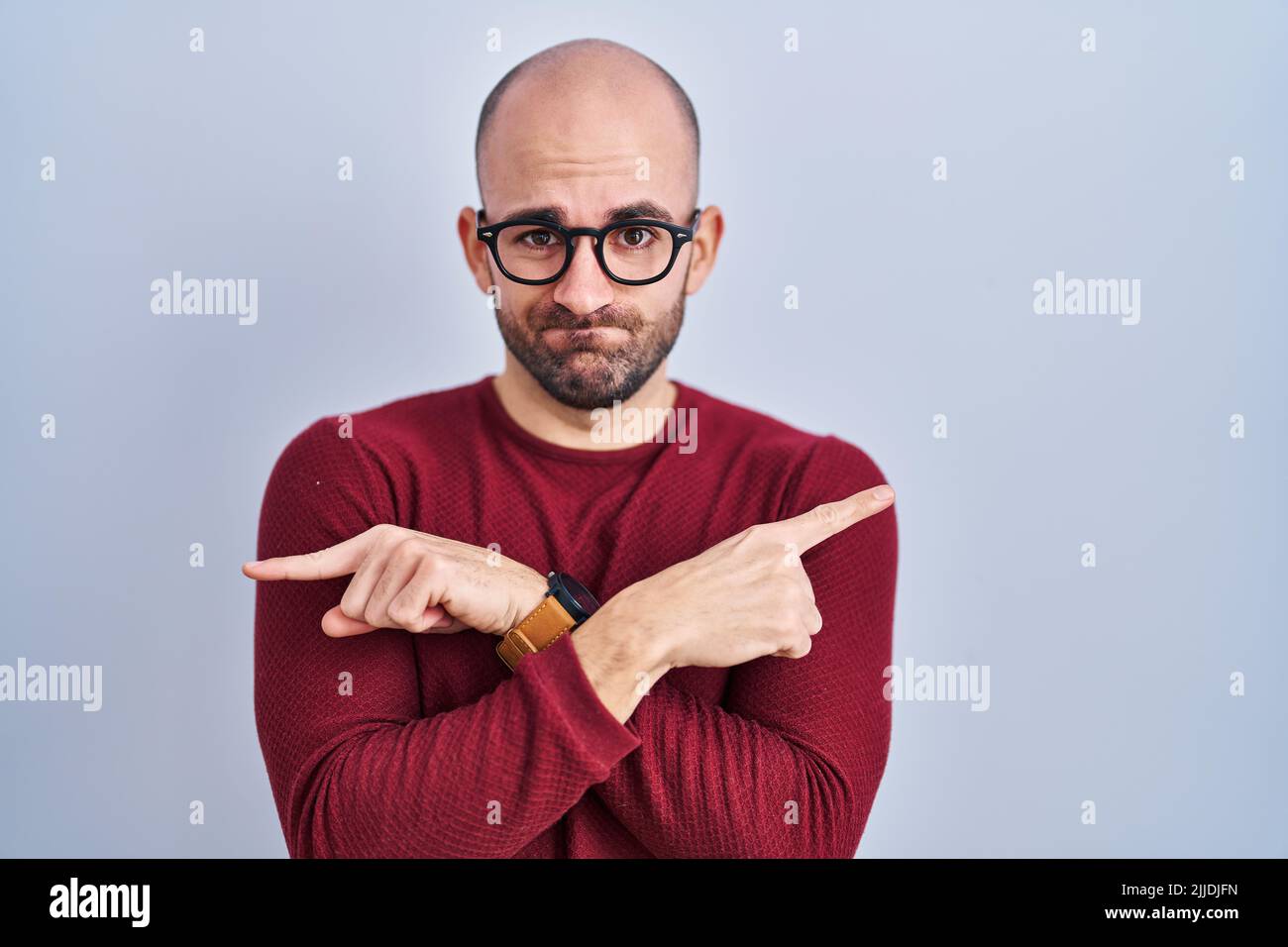Young bald man with beard standing over white background wearing ...