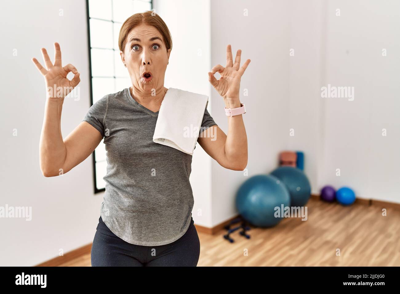 Middle age woman wearing sporty look training at the gym room looking ...
