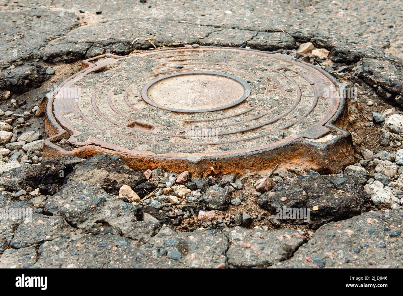 Sewer manhole on an old broken asphalt road. Road works Stock Photo - Alamy