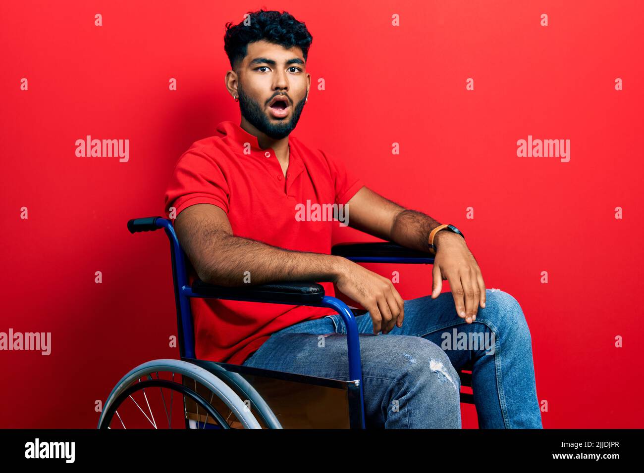 Arab man with beard sitting on wheelchair afraid and shocked with ...