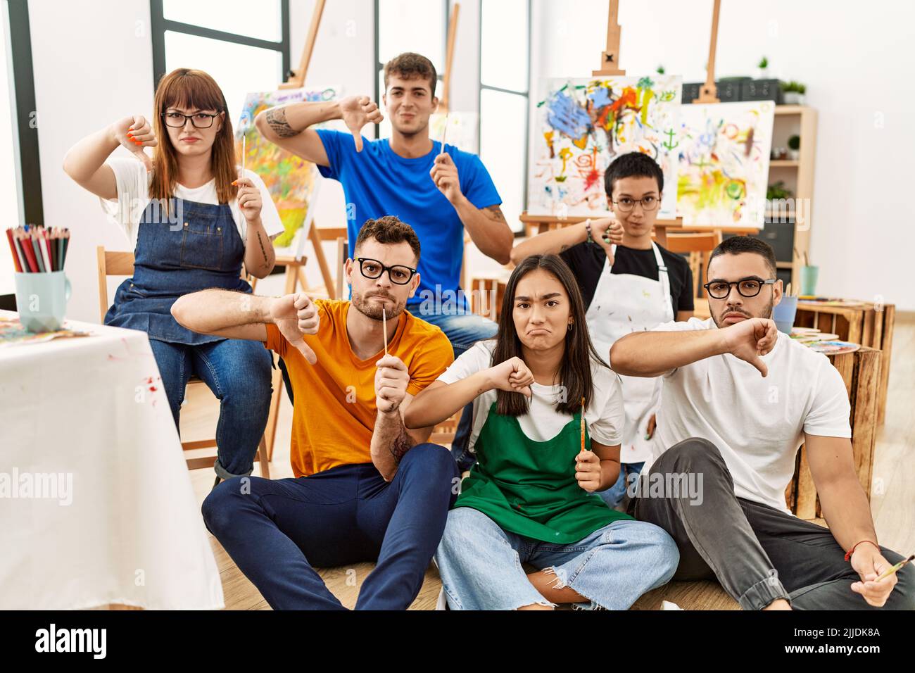 Group of people sitting at art studio with angry face, negative sign ...