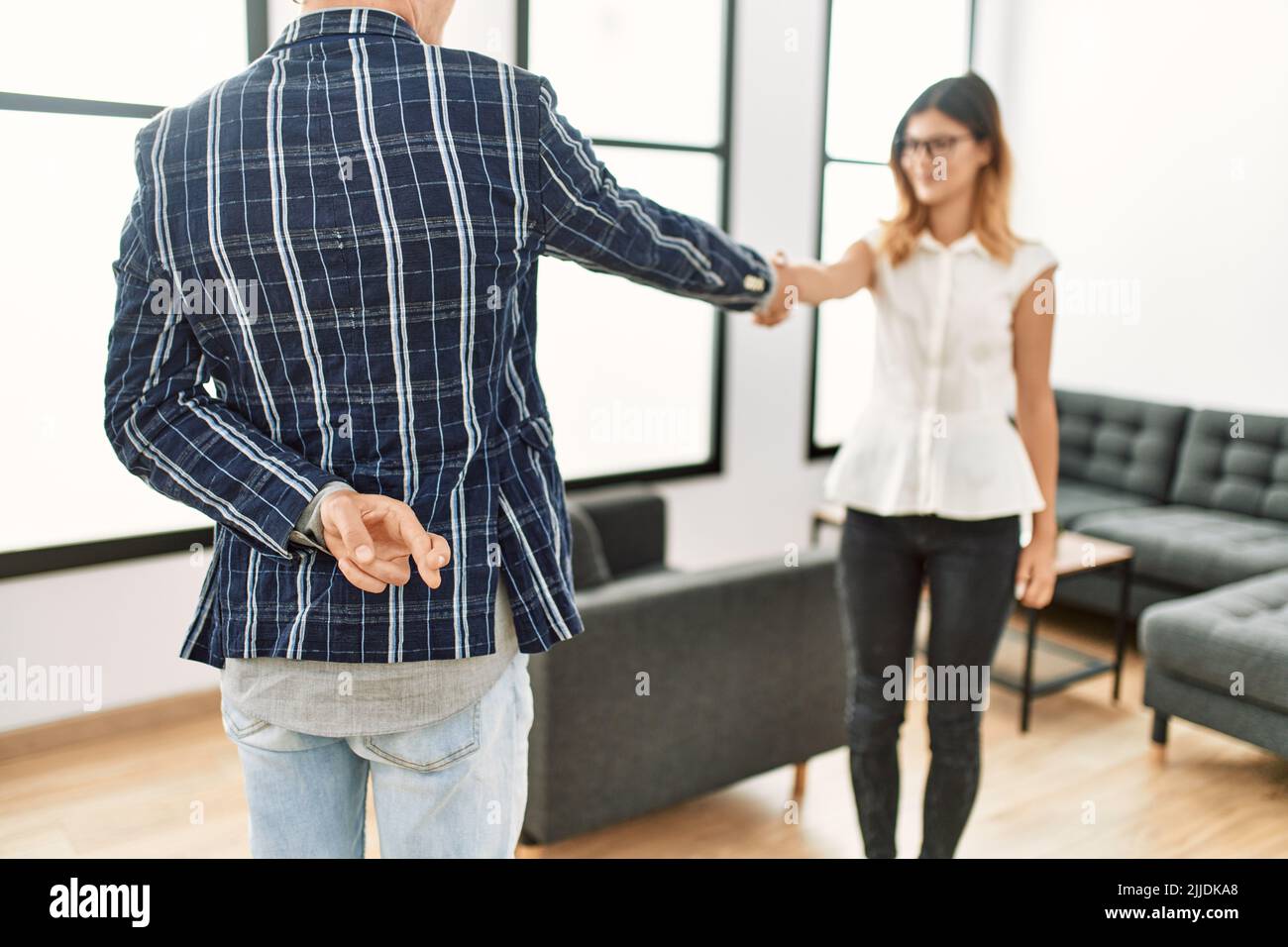 Two business workers smiling happy shaking hands. Man standing with ...