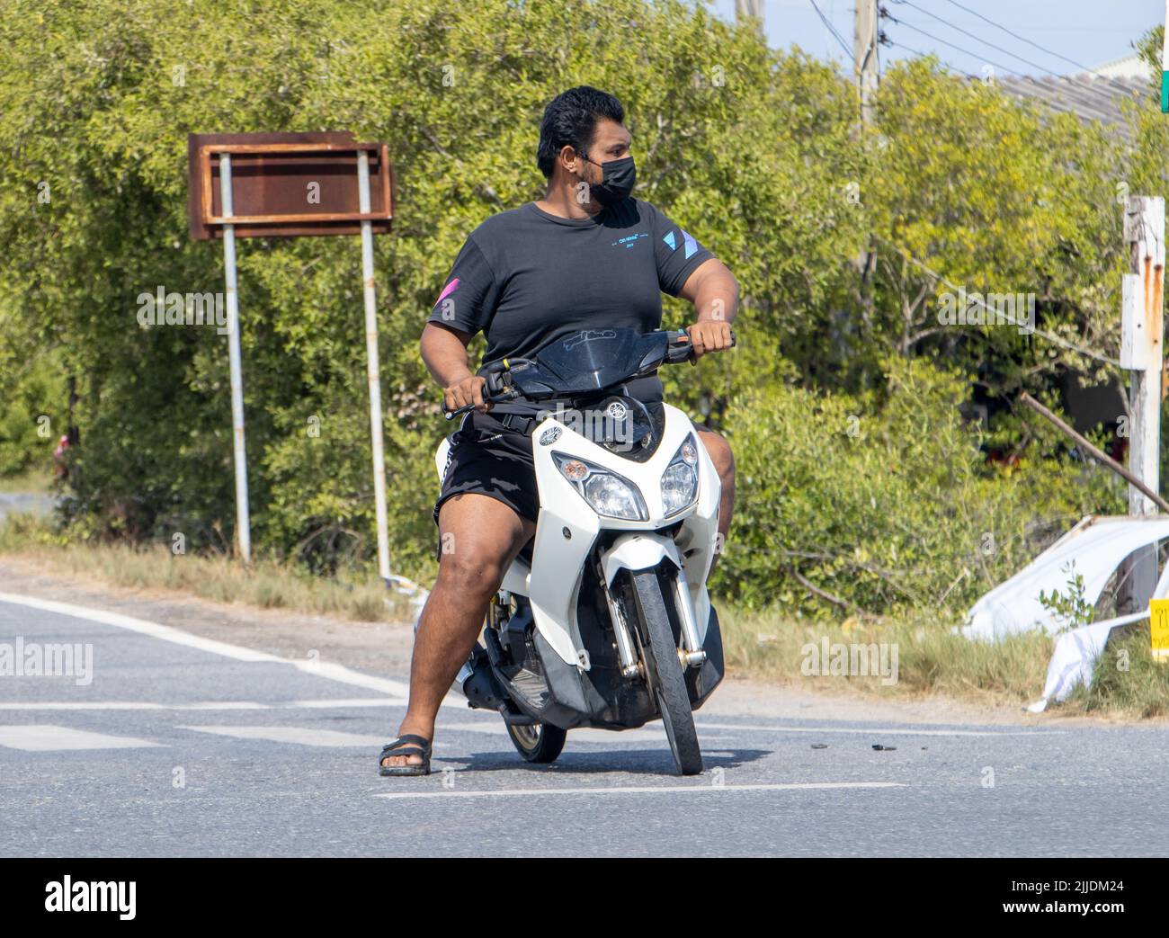 BANGKOK, THAILAND, JUNE 05 2022, A man with face mask rides a ...