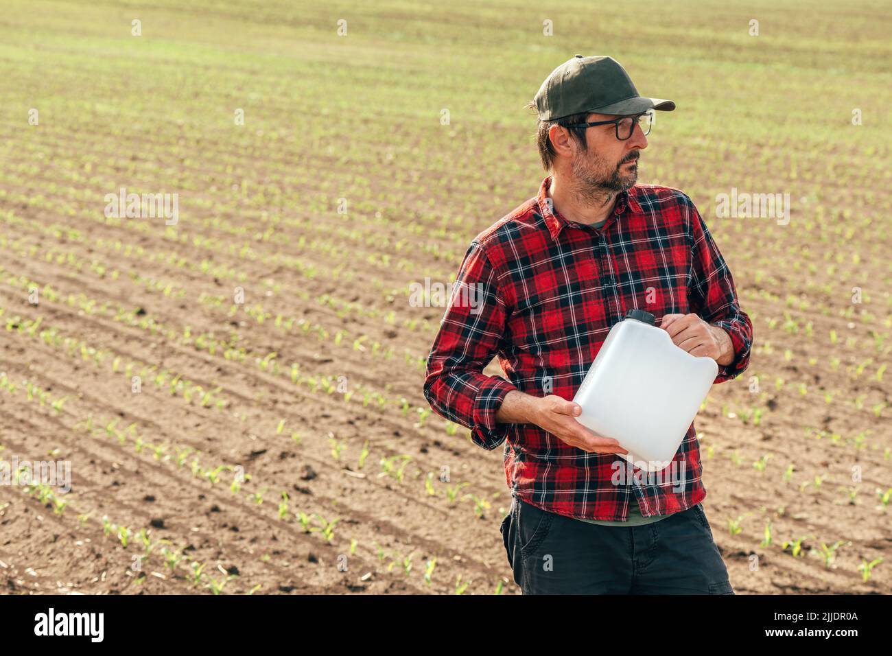 Corn crop protection concept, male farmer agronomist holding jerry can ...