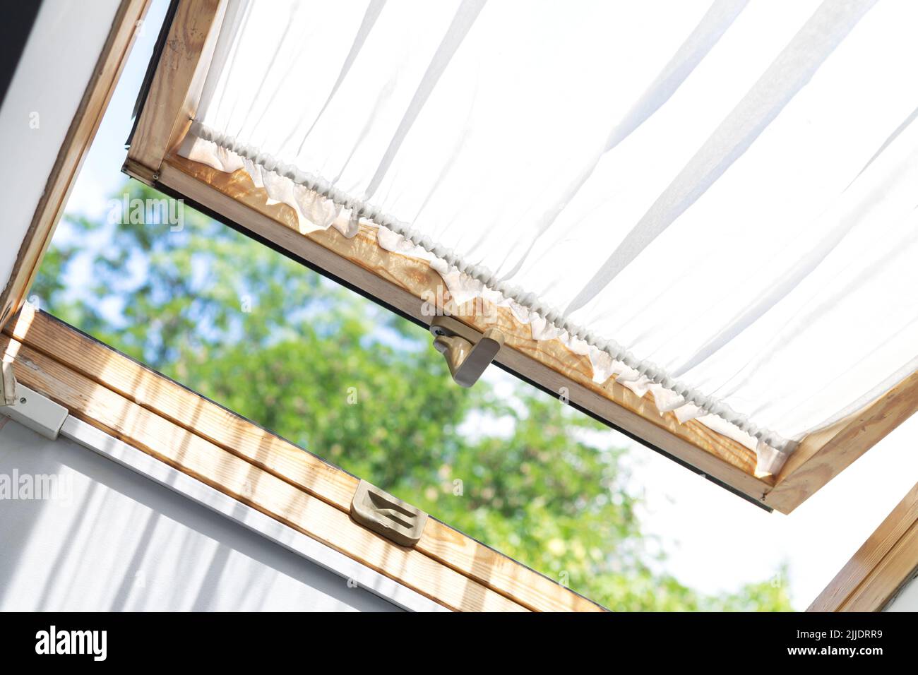 Modern open skylight (roof window or mansard window) in home attic room ...