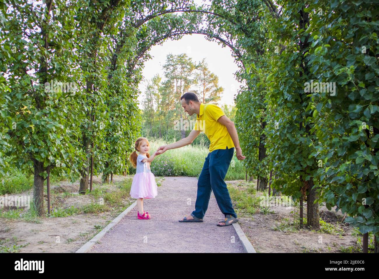 dad and daughter are dancing in nature.a little ballerina dances with ...