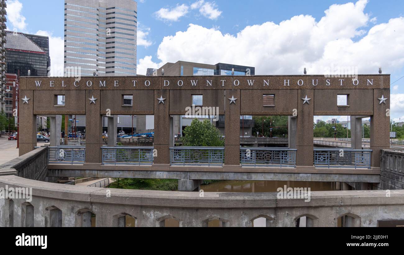 A concrete structure saying Welcome to Downtown Houston with buildings ...