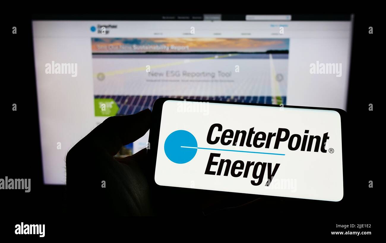 Person holding cellphone with logo of US utility company CenterPoint ...