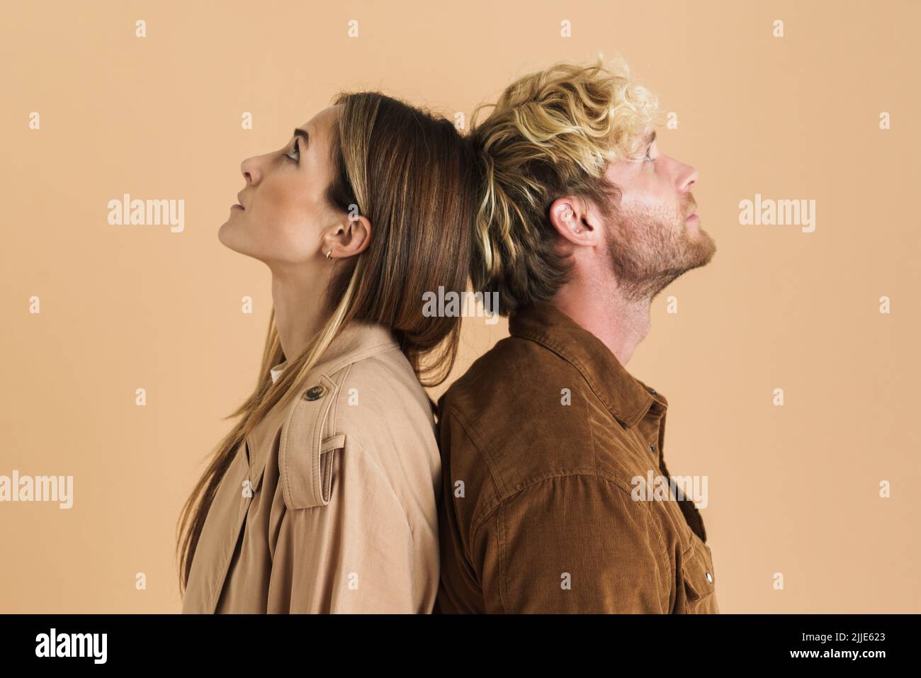 White couple looking at opposite directions while posing back to back ...