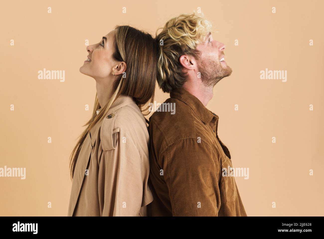 White couple looking at opposite directions while posing back to back ...