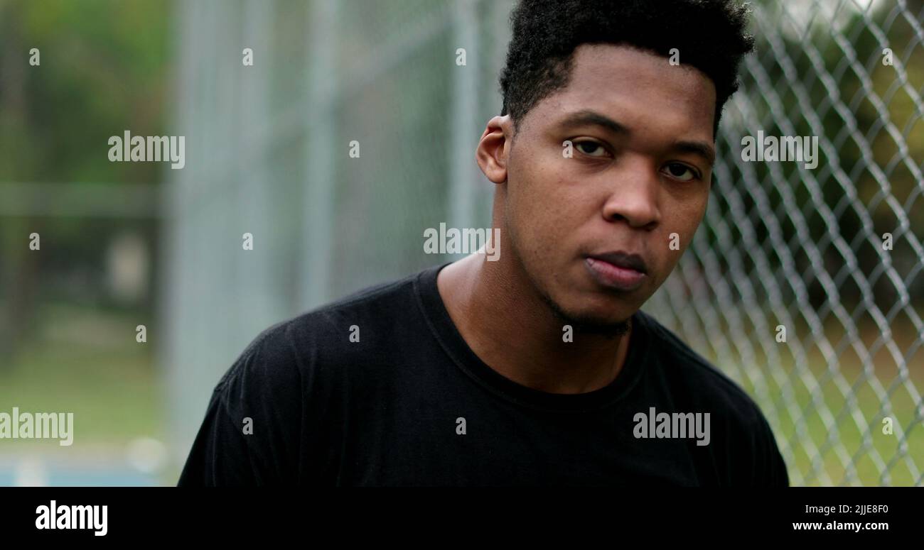 Serious black African man looking at camera walking backwards Stock ...