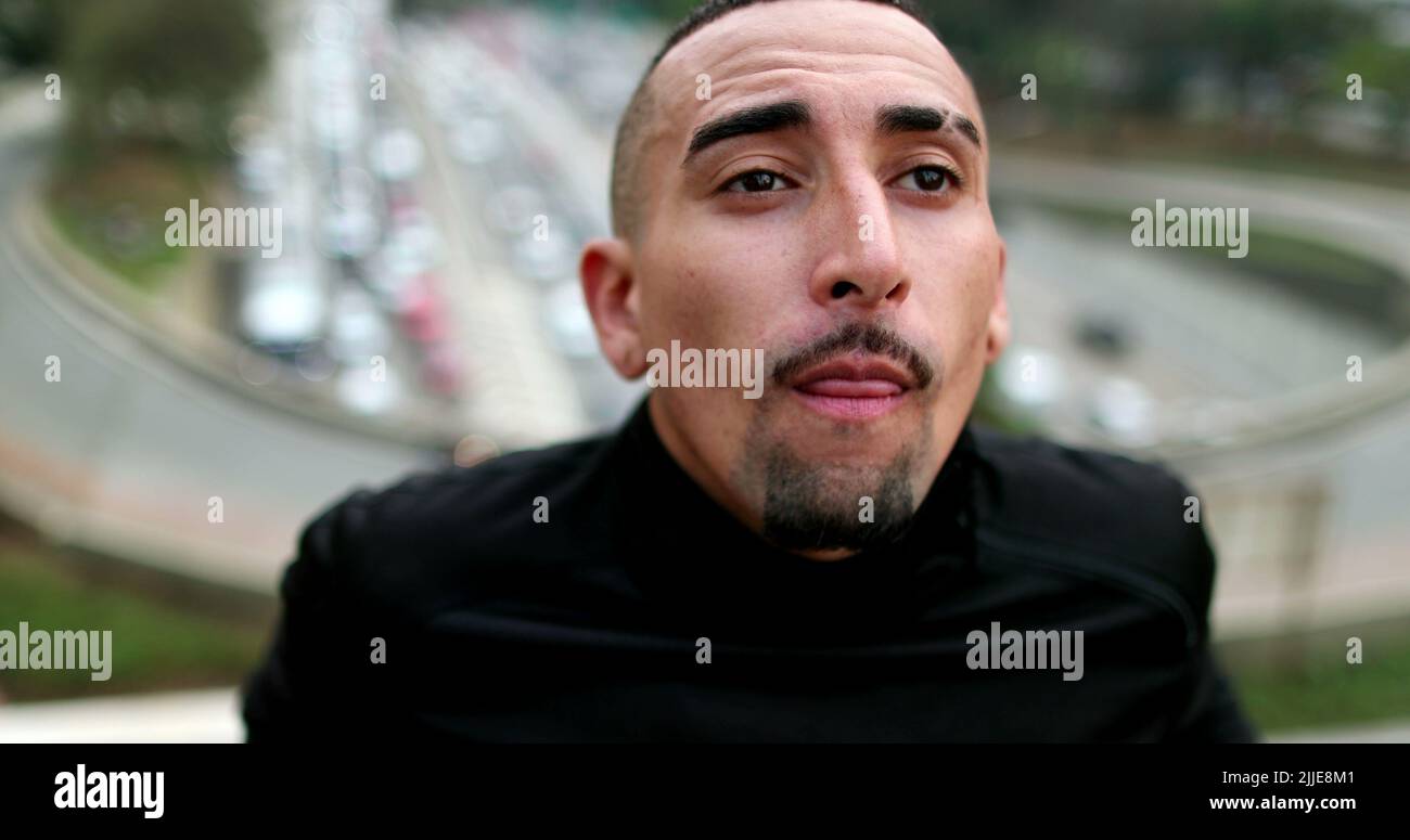 Thoughtful hispanic man in downtown city thinking, real people Stock ...