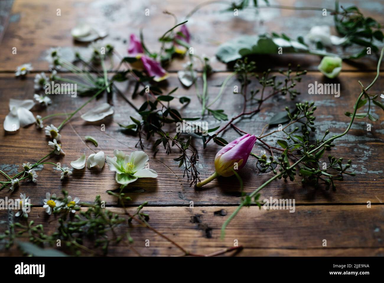 Horizontal image of mixed florals on a rustic wood table in moody ...