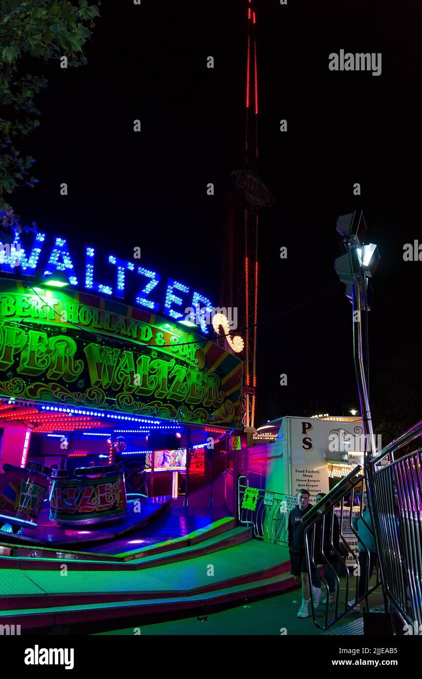 A brightly lit waltsers fair ride at the annual Mayfair at night Stock ...