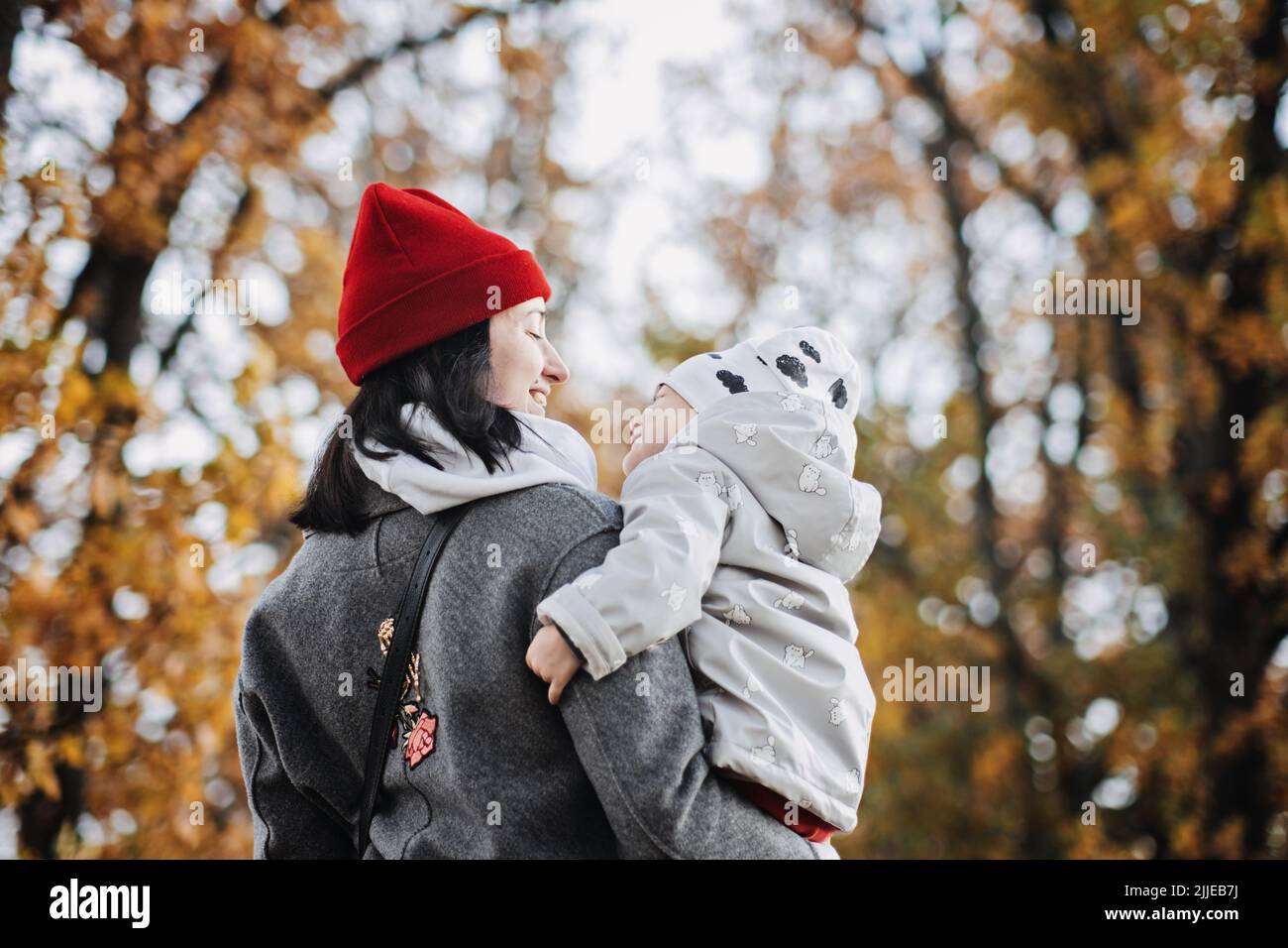 Mother and little baby daughter walking together in autumn park, forest ...