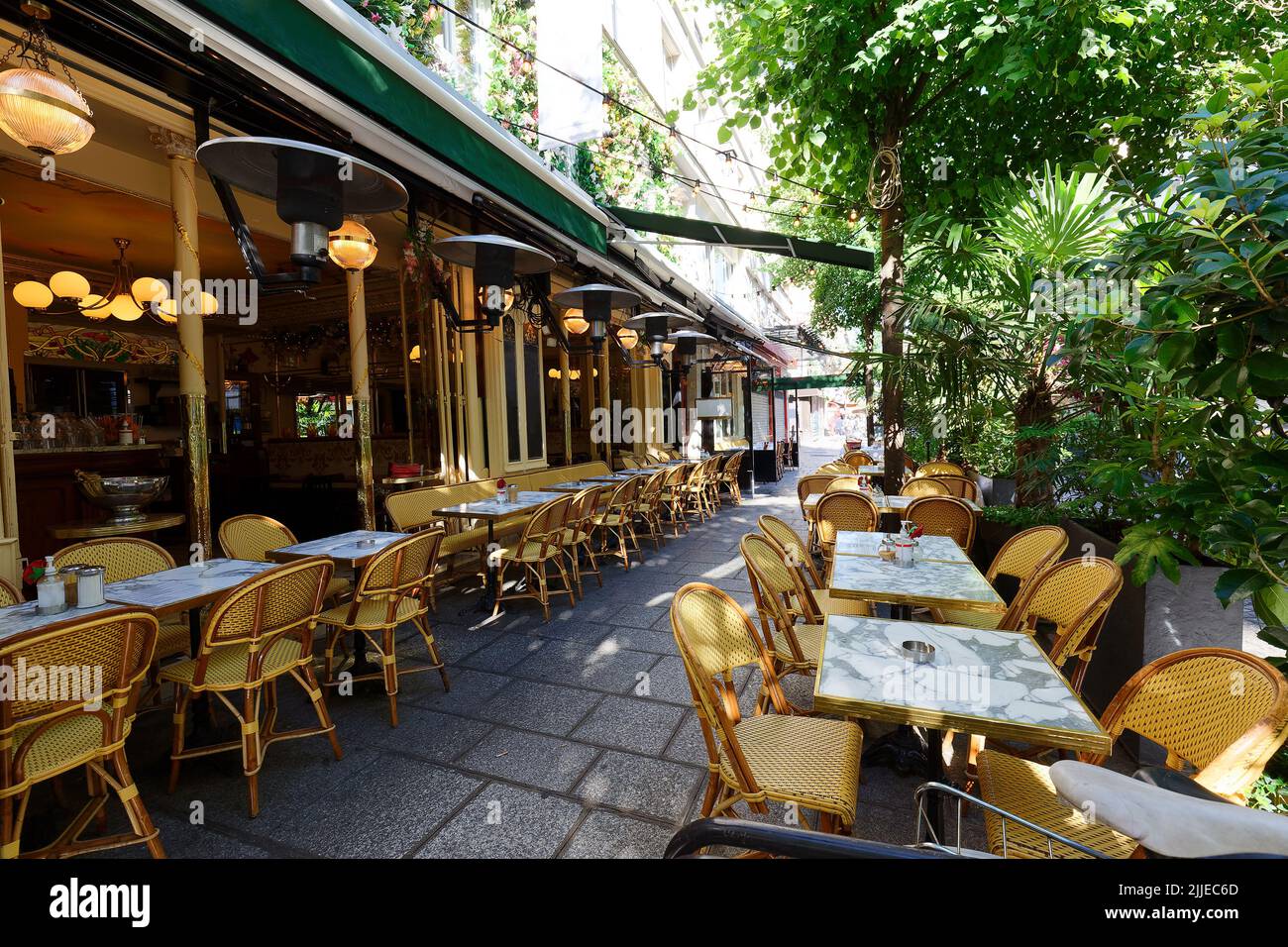 Cosy street with round tables and bright chairs of traditional outdoor ...
