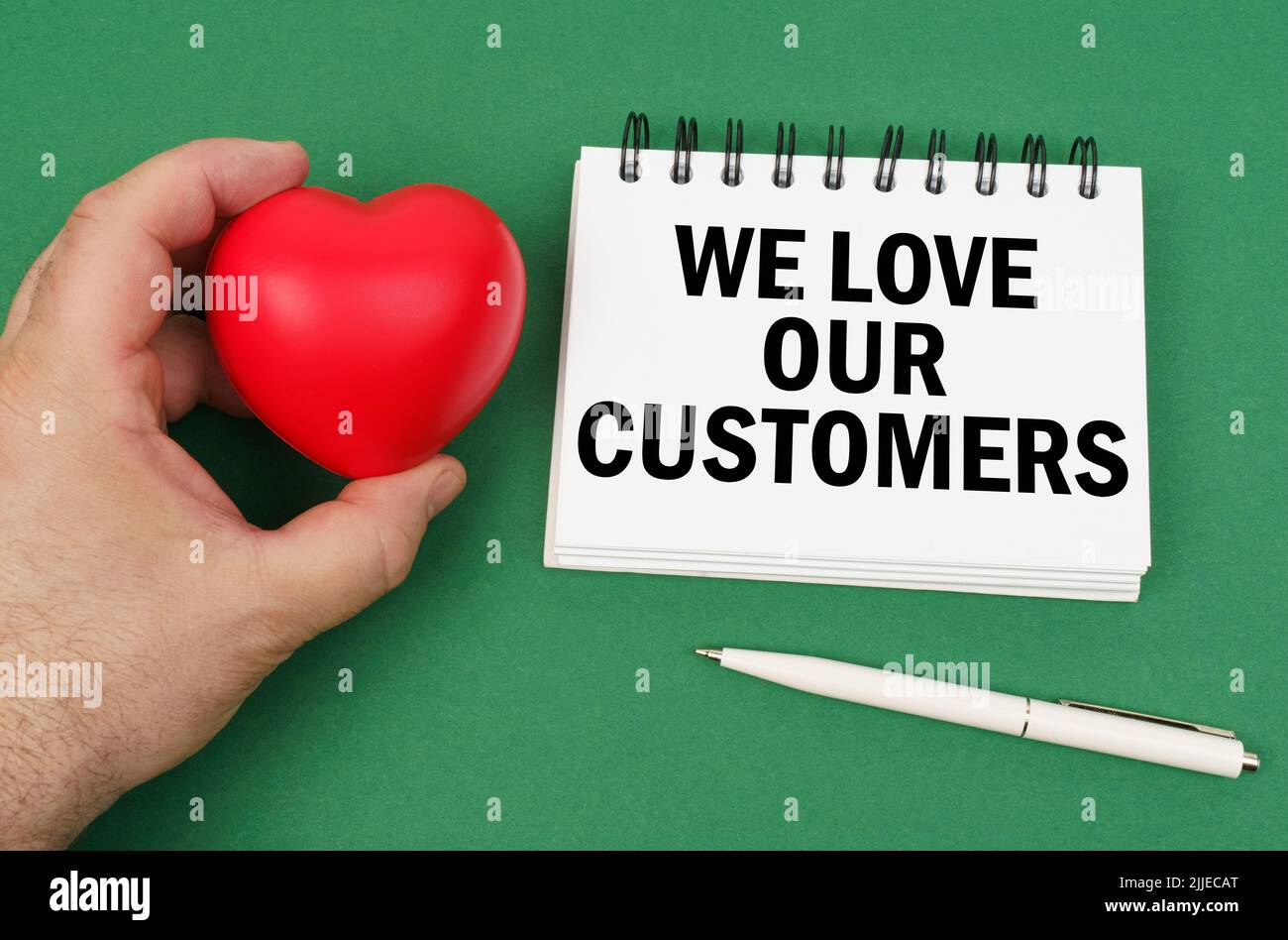 On the green surface are a pen, a notepad with the inscription - We ...