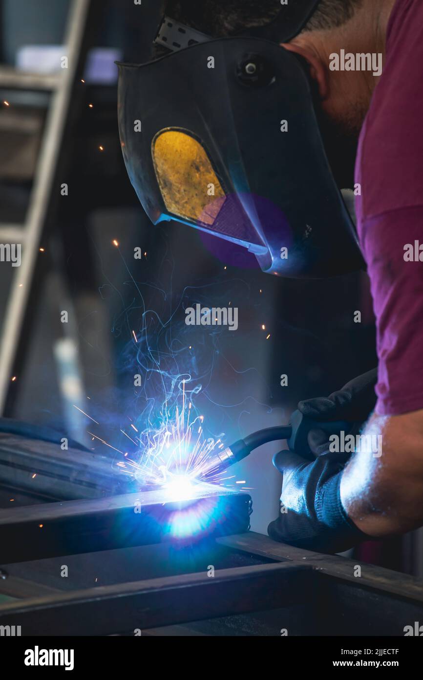 Handyman performing welding and grinding at his workplace in the ...