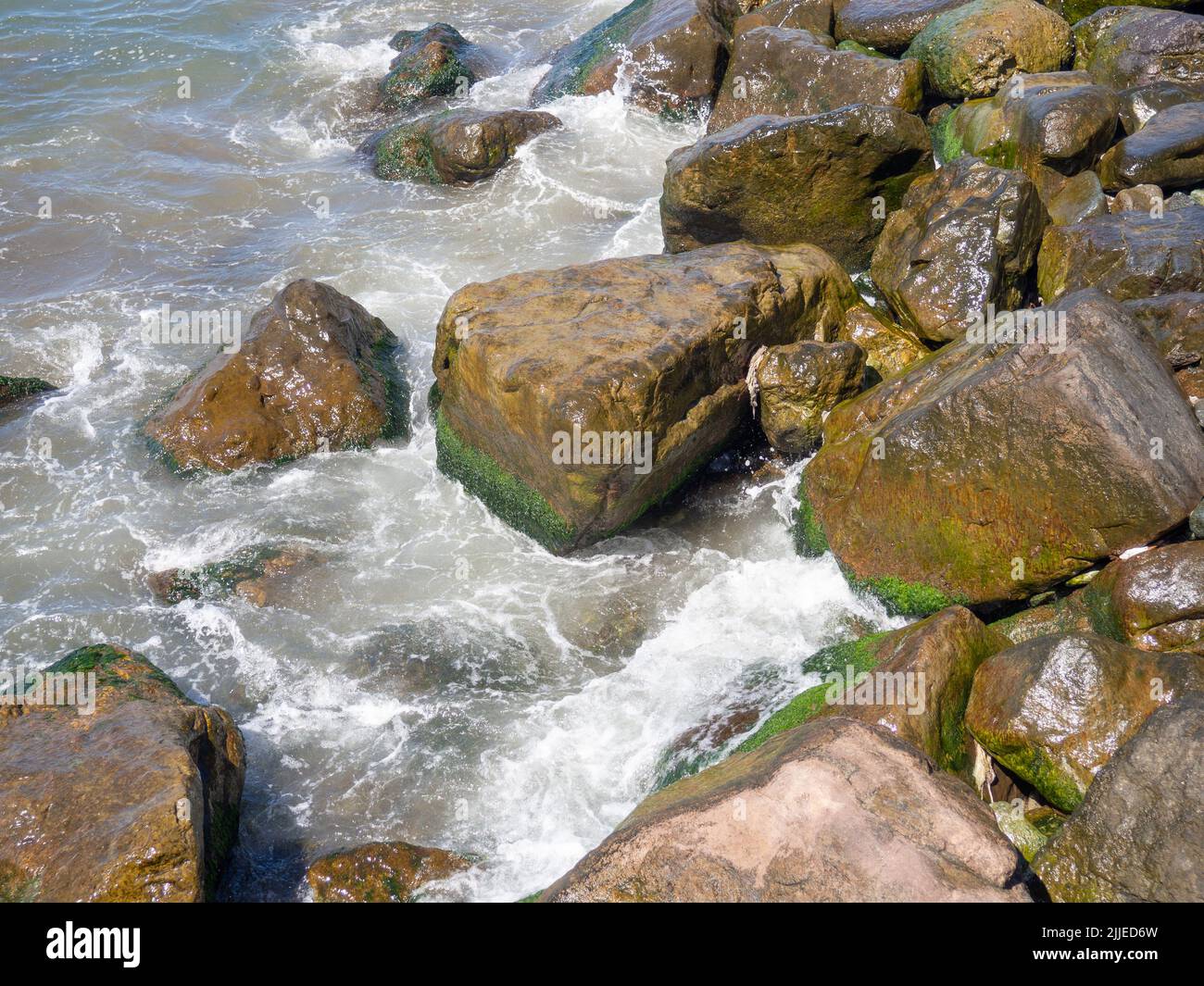 Surf. Waves crash on big rocks. Rocky coast and wave. Fortified ...