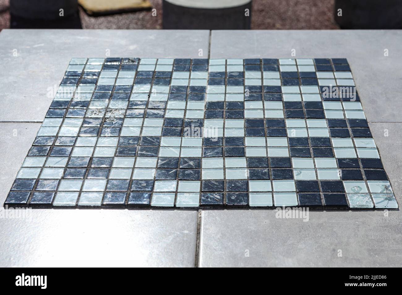 Chess or checker board made with pieces of glass, some broken, in white ...