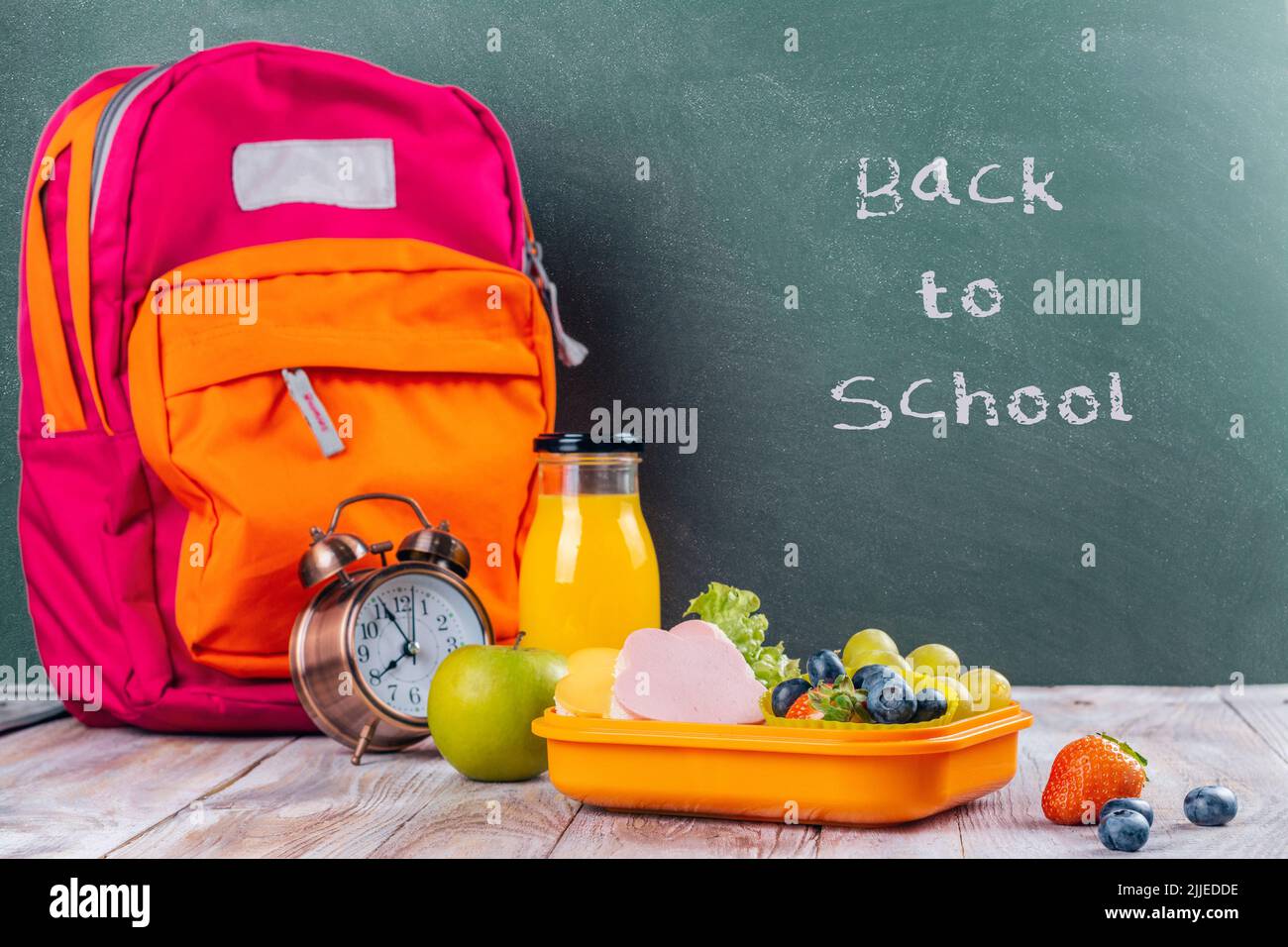 Colorful school backpack and lunch box with fruits, sandwich and juice ...