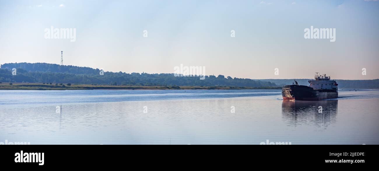 A large cargo barge transports cargo by river to the main port for ...