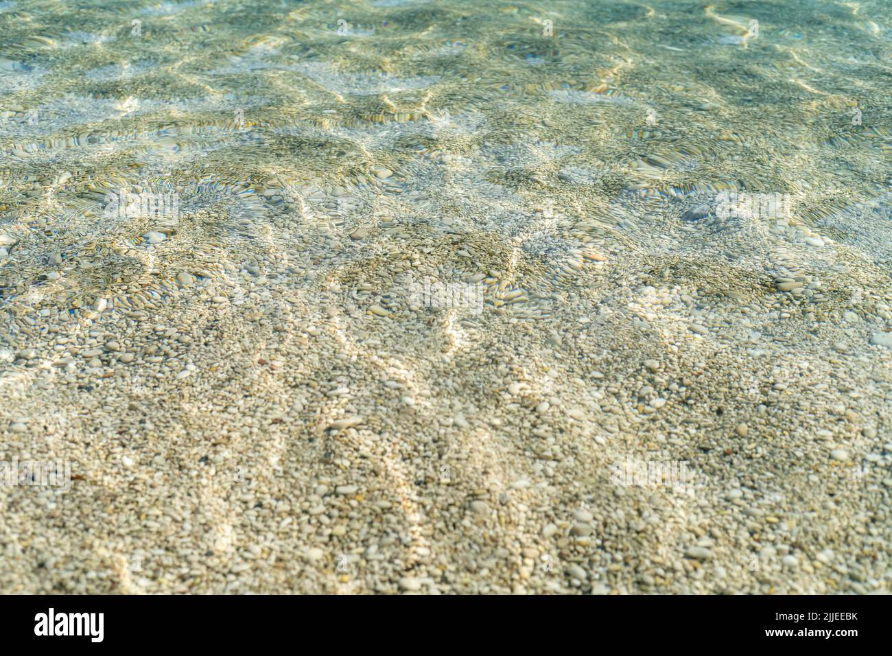 Close up photo of clear sea with pebbles and ripples Stock Photo - Alamy