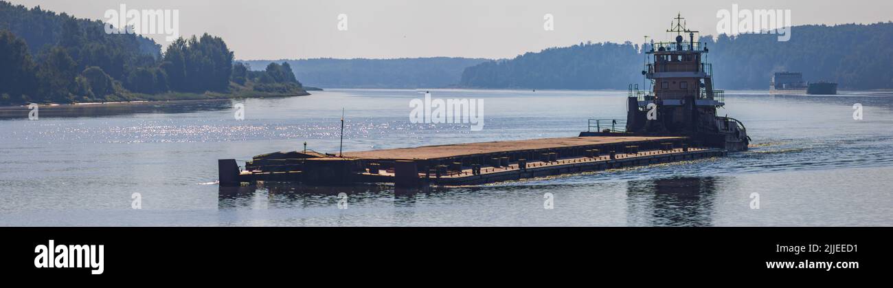 A large cargo barge transports cargo by river to the main port for ...