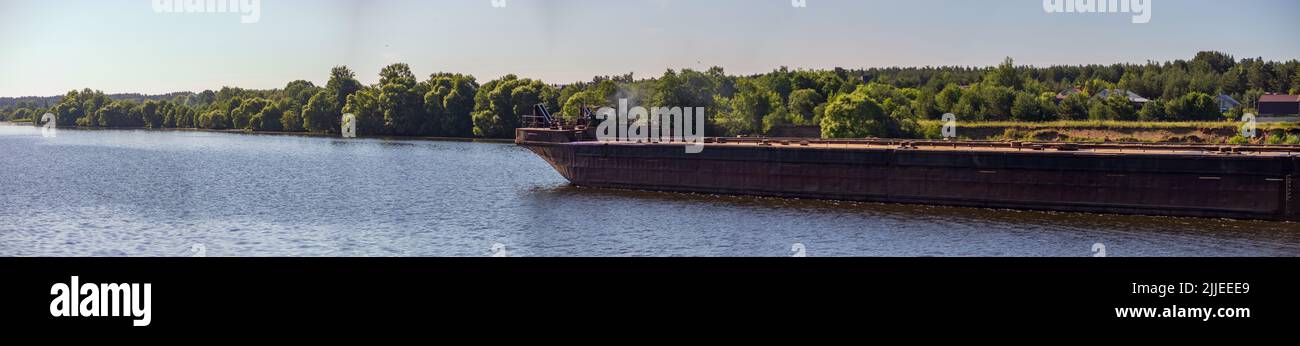 A large cargo barge transports cargo by river to the main port for ...