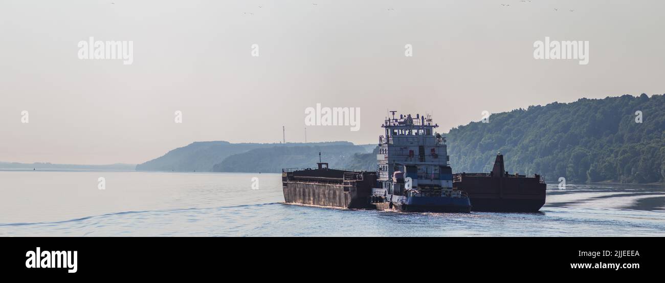 A large cargo barge transports cargo by river to the main port for ...