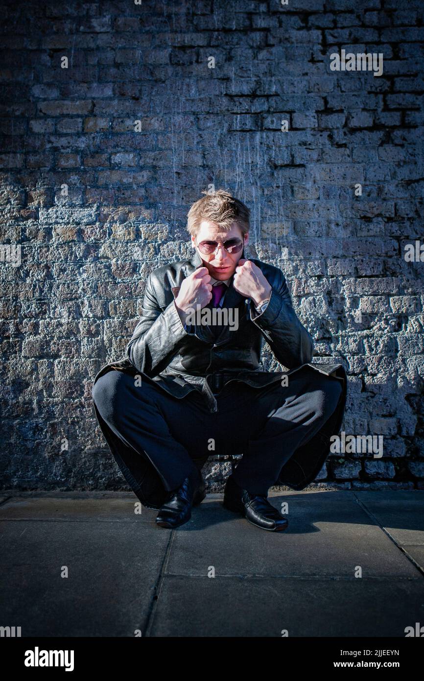 Undercover; surveillance. A spy hiding in the shadows is revealed by a ...