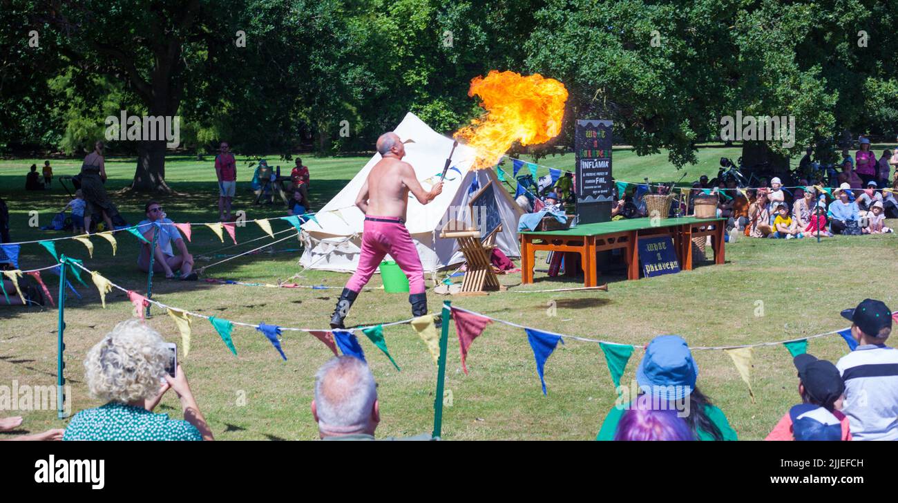 Crowd looking on as a performance artist enthrals an onlooking crowd ...