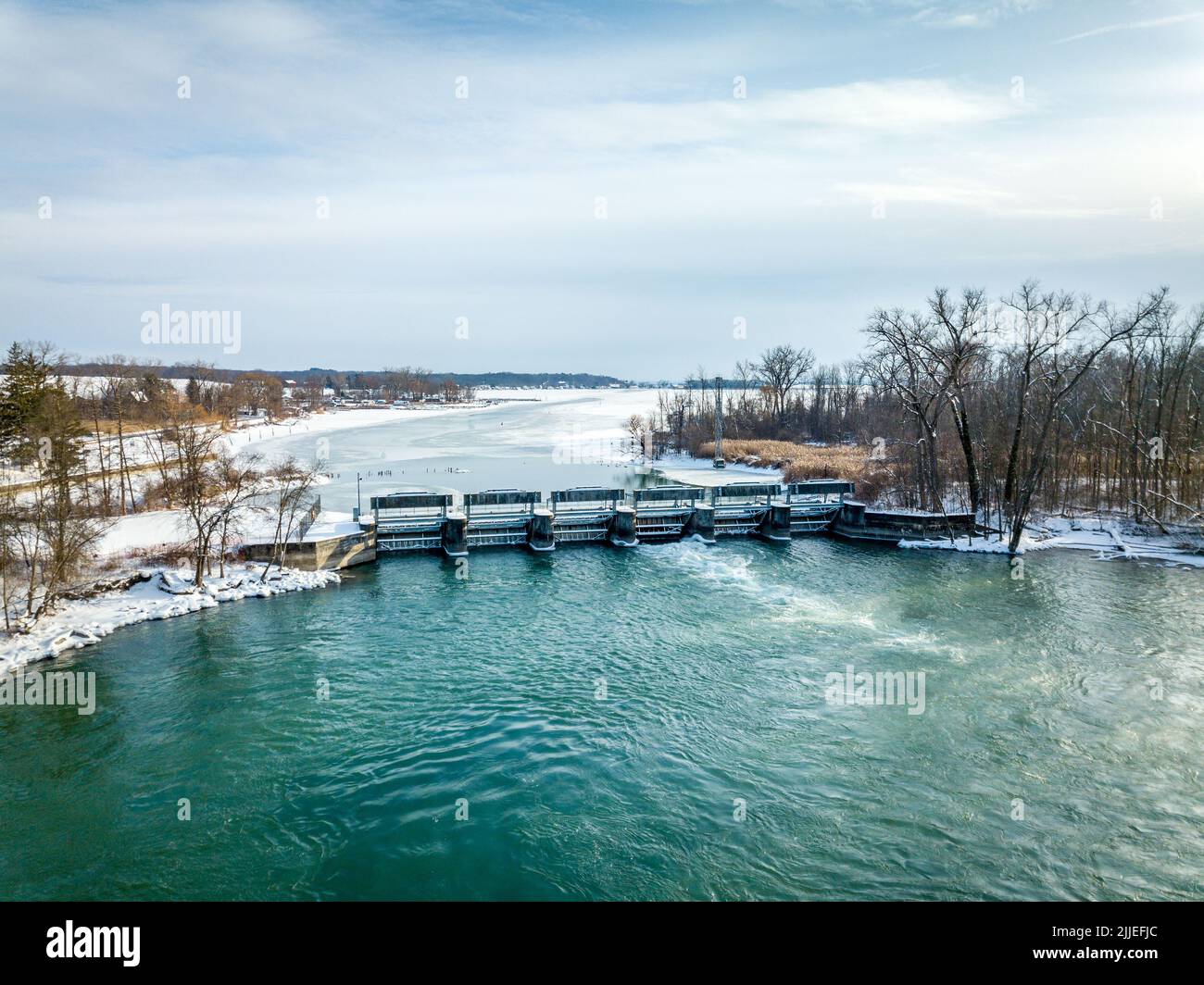 Dam on an ice-covered river along the snowy fields Stock Photo - Alamy
