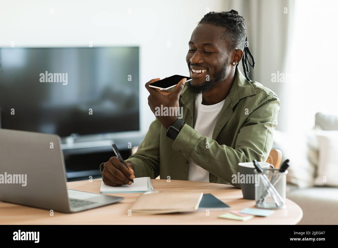 Digital speaker application. Happy black male freelancer using voice ...