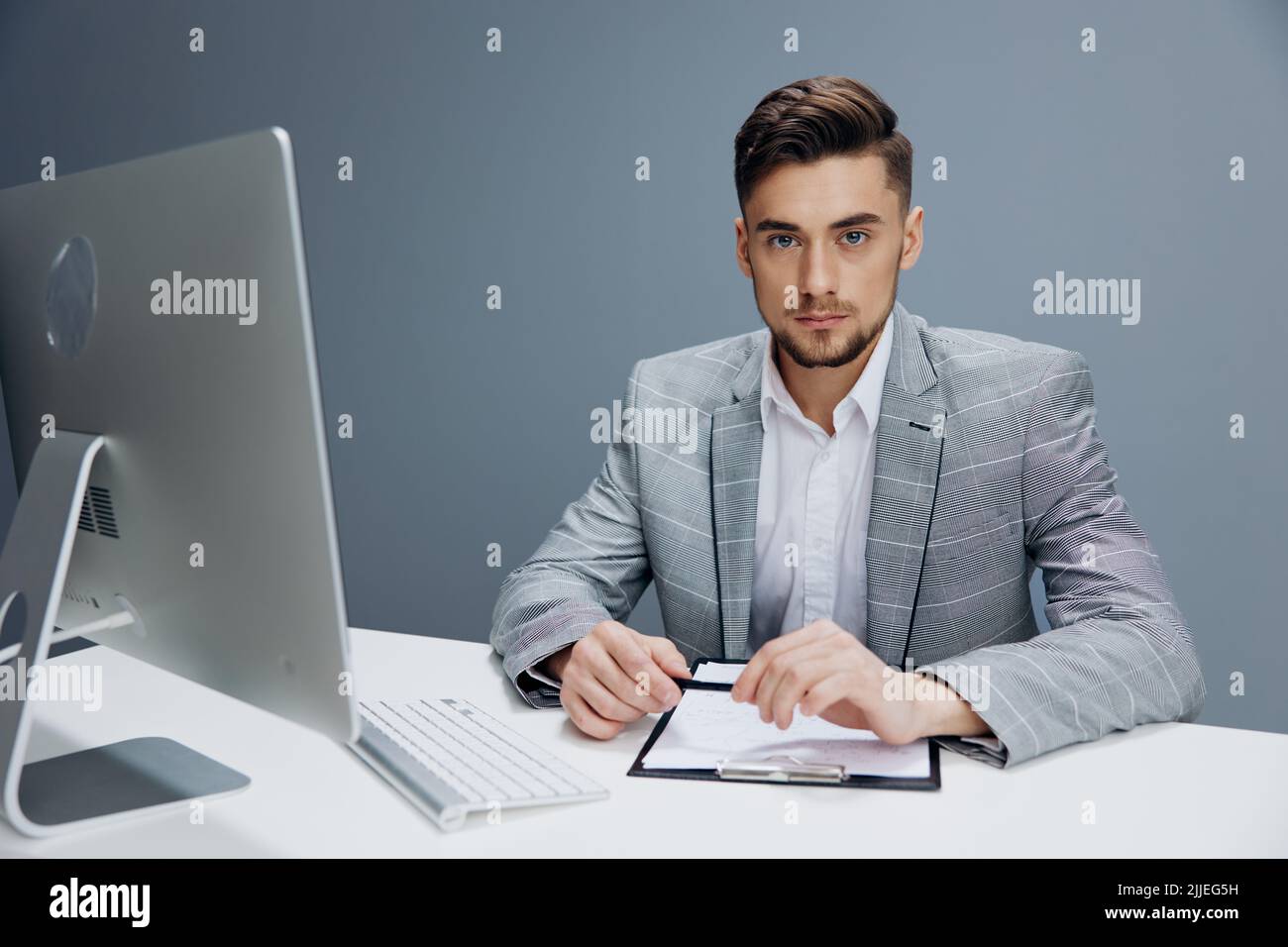 businessmen in a gray suit sits in front of a computer technologies ...