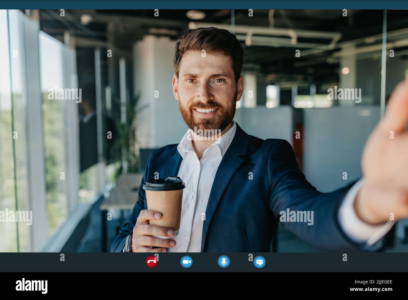 Video conference. Positive businessman making virtual call and drinking ...