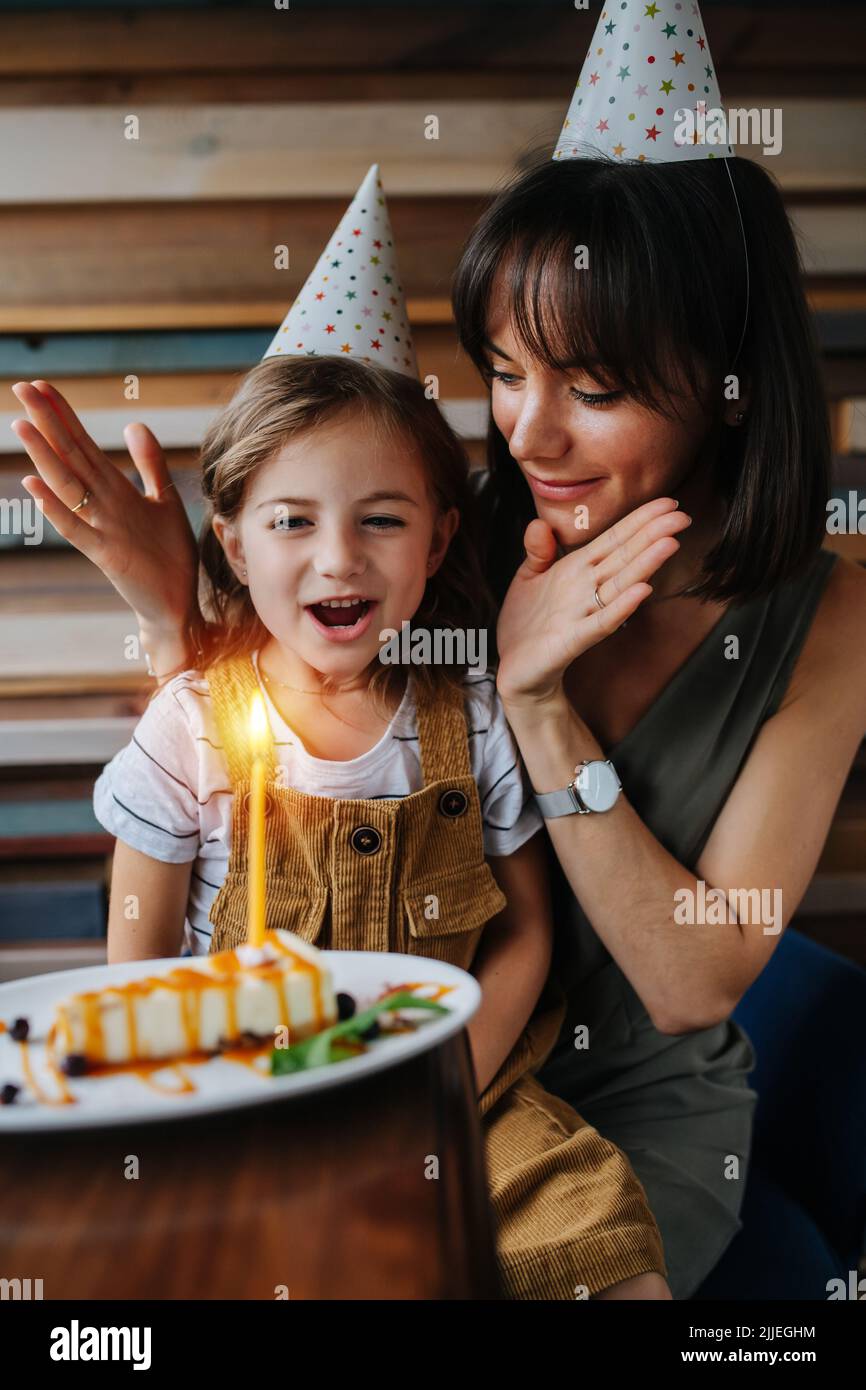 Happy mom celebrating her daughter's birthday with her. Both wearing ...