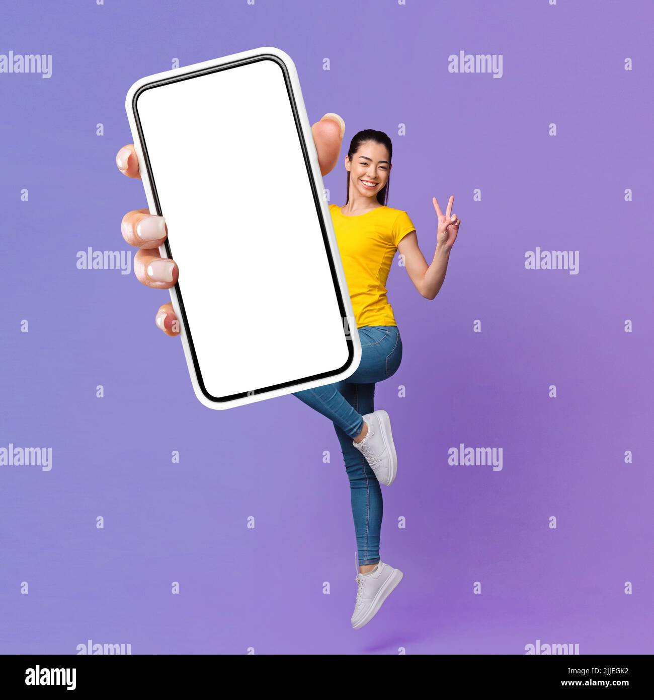Cheerful Asian Lady Jumping In Air And Showing Smartphone Stock Photo ...