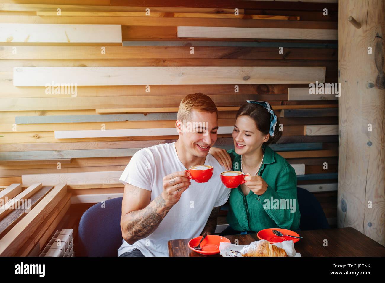 Happy chatting couple sitting in a corner of small cafe next to each ...