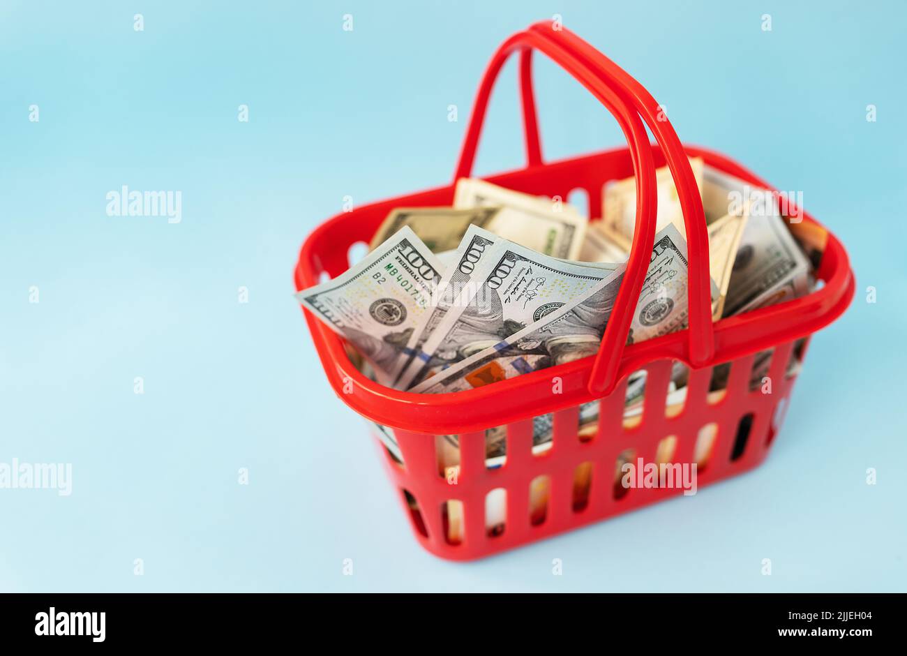 Red grocery cart with many 100 dollar bills inside. The concept of ...