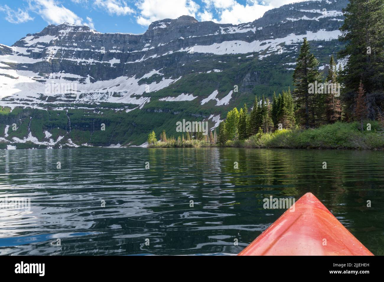 A red kayak on Cameron Lake in Waterton National Park, enjoying the ...