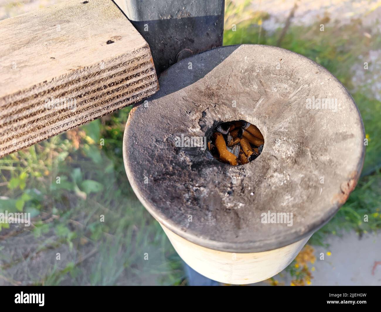 Cigarette bin with smoked cigarettes hangs outside on a pole Stock ...