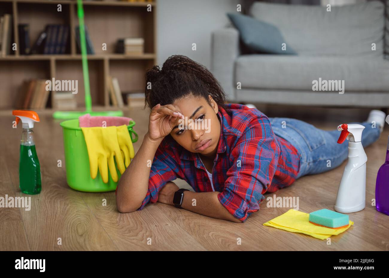Sad tired millennial african american woman housewife with cleaning ...