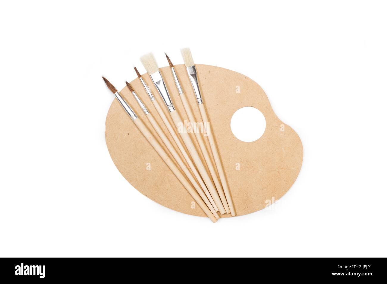 Paintbrushes on a wooden painter palette on a white background with ...
