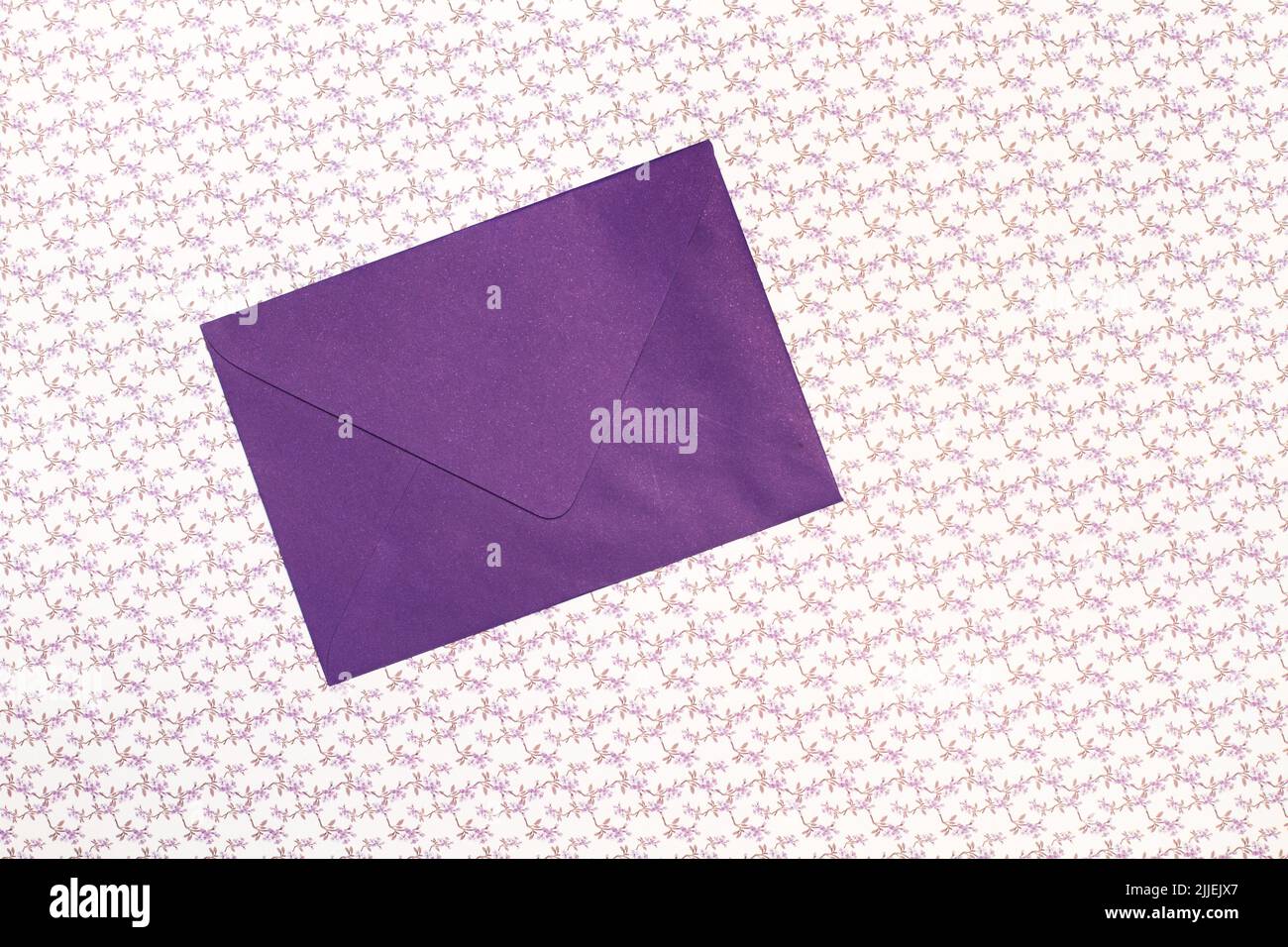 A purple envelope on a purple flowers background with copy space Stock ...