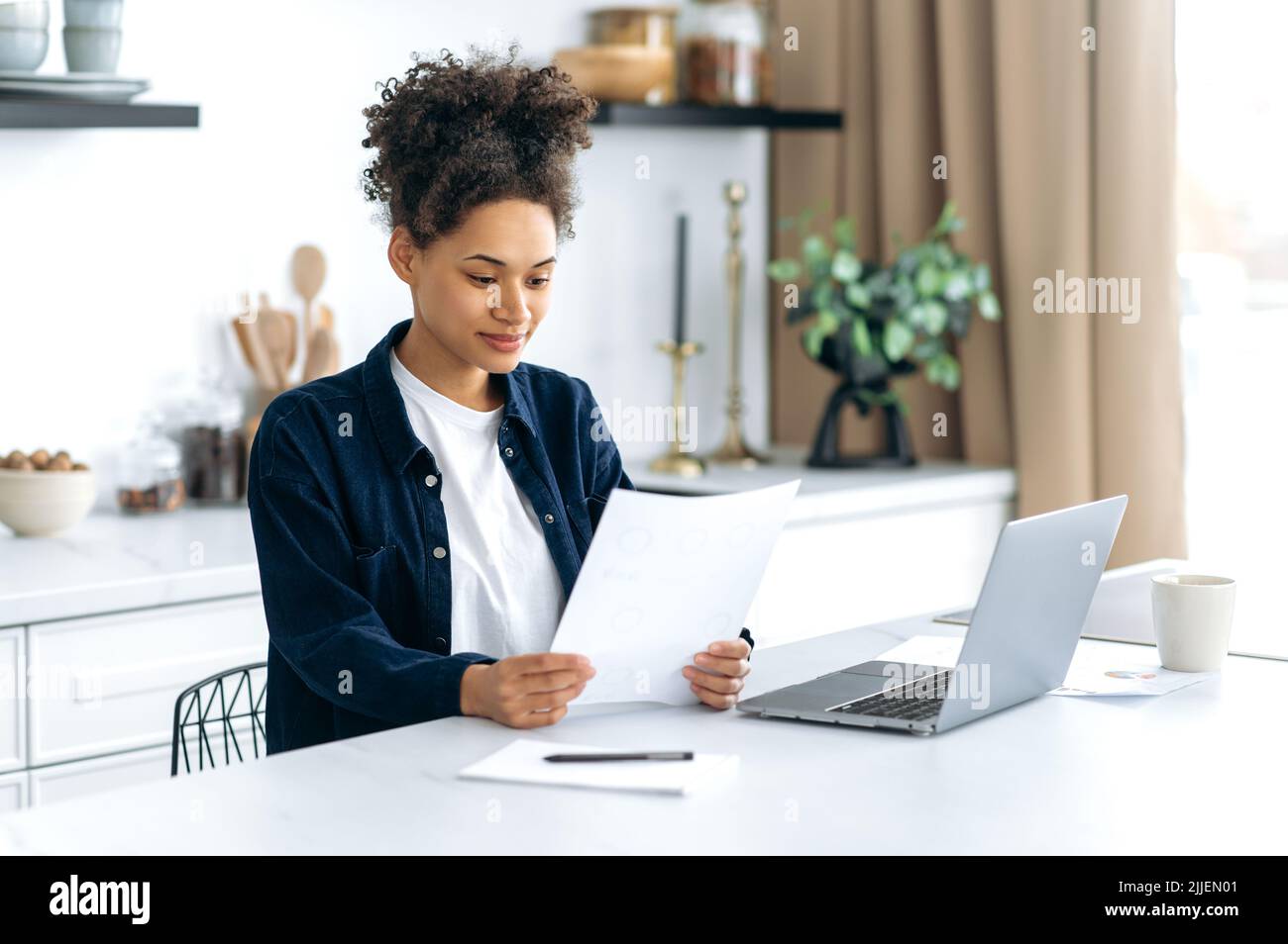 Positive clever young adult african american curly haired woman ...