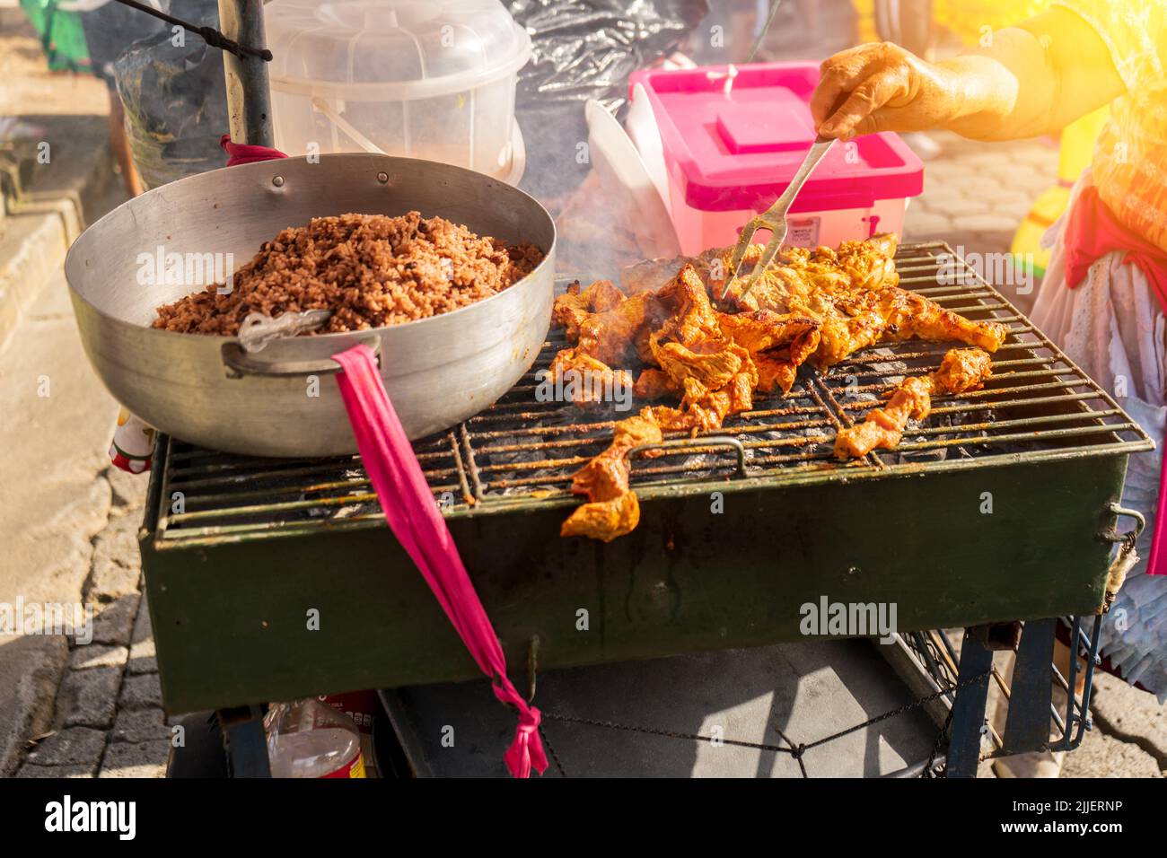 Hand of an elderly woman arranging meat on an outdoor grill Stock Photo ...
