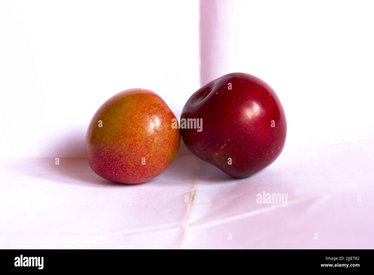 A plum fruit with red apple on white background Stock Photo - Alamy