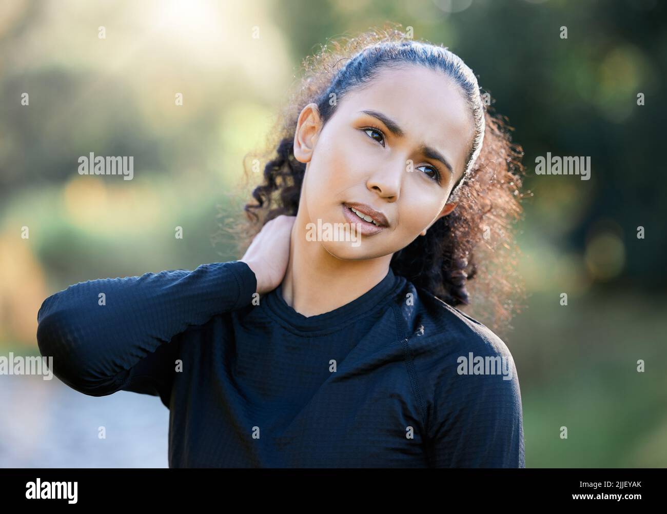 This feels a bit weird. a sporty young woman experiencing neck pain ...