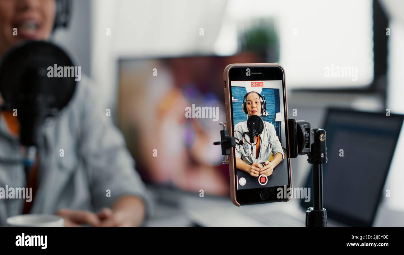 Social media content creator recording vlog with touchscreen phone ...